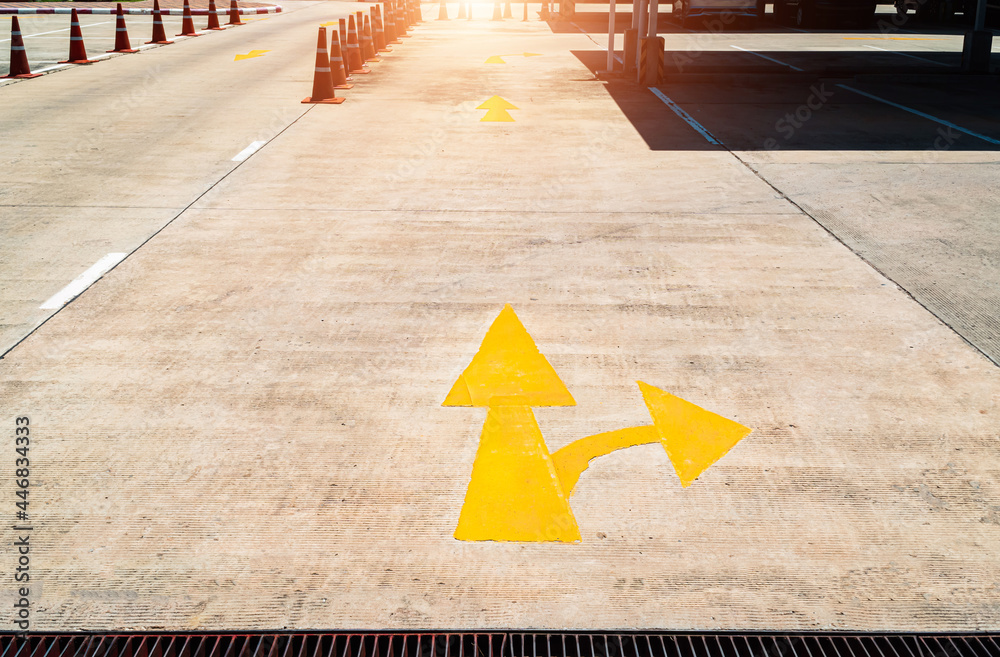 The yellow arrow on the concrete road marks the entrance to the parking ...