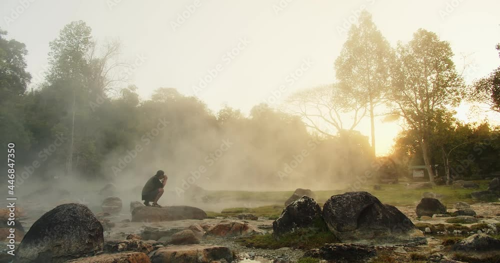 Young tourist traveler man sitting relaxing on the rock and taking ...