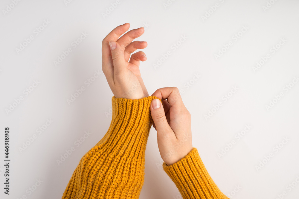 First person photo of woman's hands pulling on sleeve of yellow sweater ...
