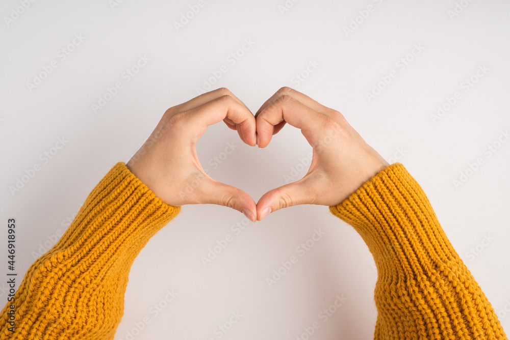 First person photo of woman's hands making heart with fingers on ...