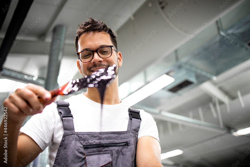 Printing machine operator mixing paint and checking density before ...