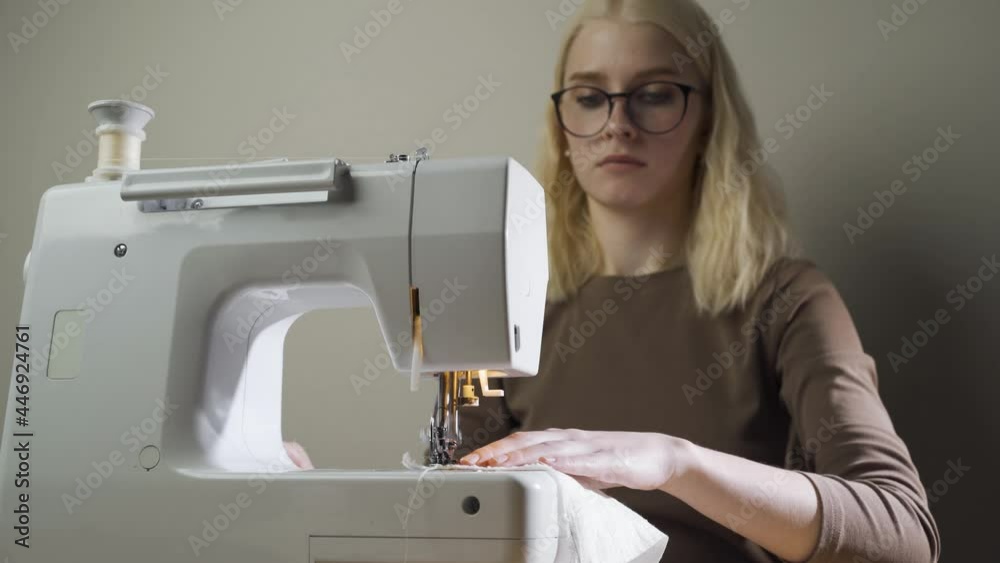 The seamstress lays a line on the product behind the sewing machine ...
