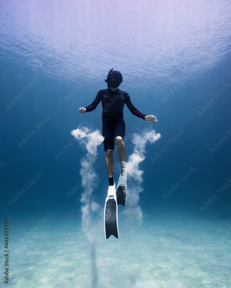 Person freediving in the ocean, playing with sand Stock Photo | Adobe Stock