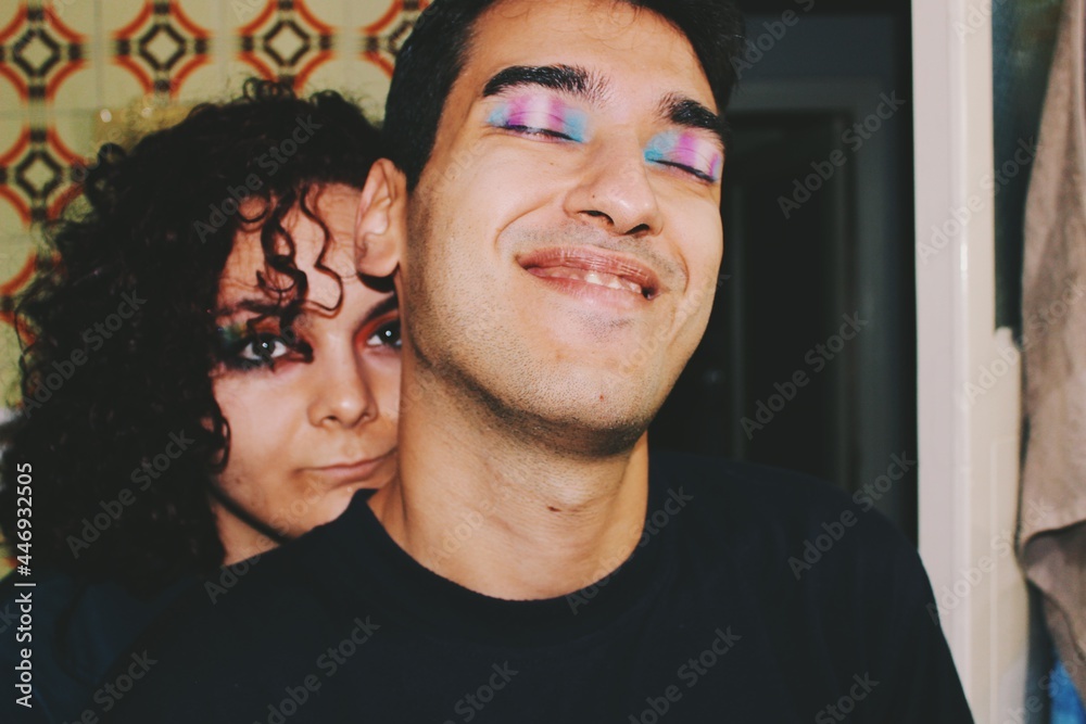 Portrait of queer friends / young couple wearing eyeshadow makeup of ...