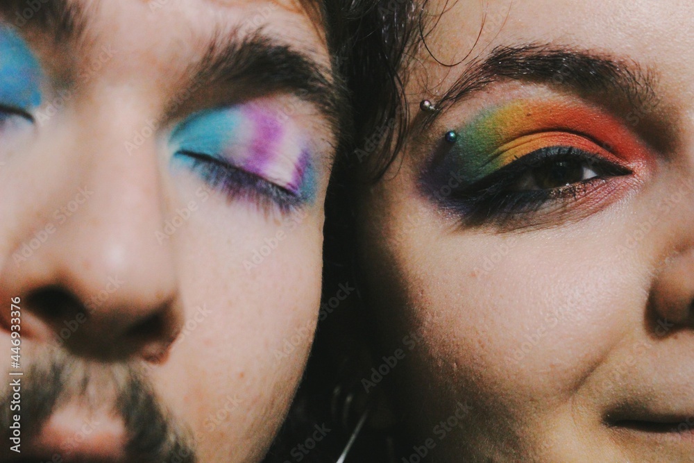 portrait of closeup faces of two lgbtq queer friends faces with rainbow ...