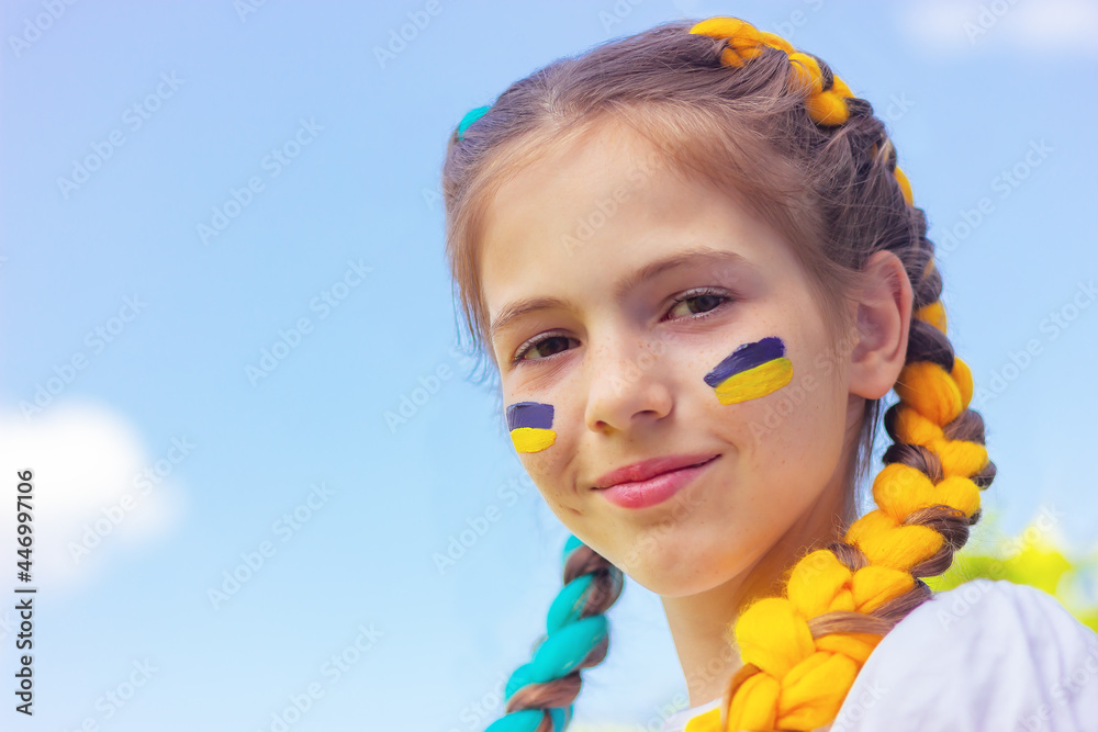 smiling Ukrainian girl with blue and yellow flags painted on her face ...
