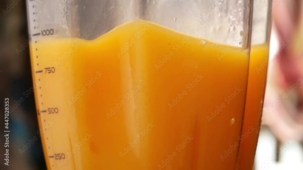 Close up of blended tropical mango in a blender. Sweet mango fruit with ...