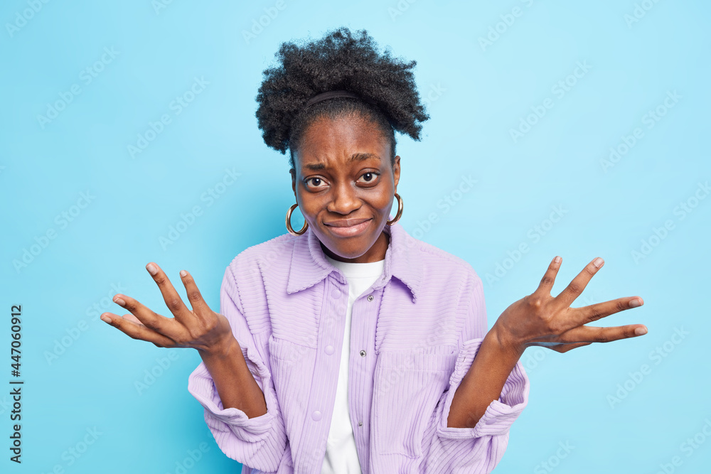 Puzzled discontent dark skinned female model gestures in bewilderment ...