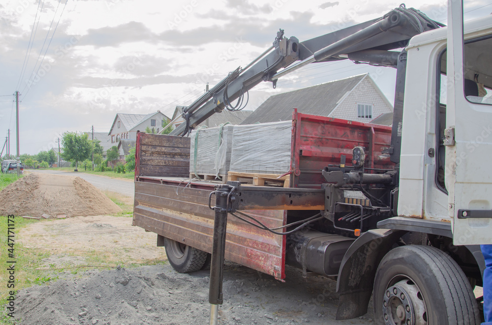 Loading a pallet with paving slabs on a truck. Stock Photo | Adobe Stock