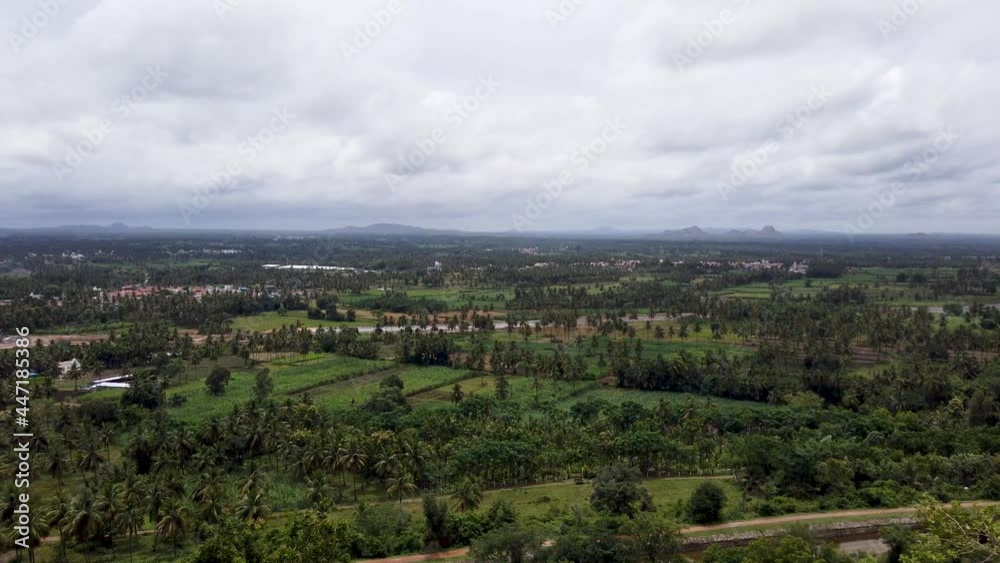 A Pan view of the Countryside and the hill range with Palm groove ...