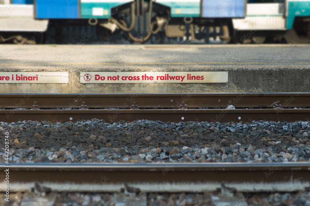 Warning sign in train station in Italy: do not cross the railway lines ...