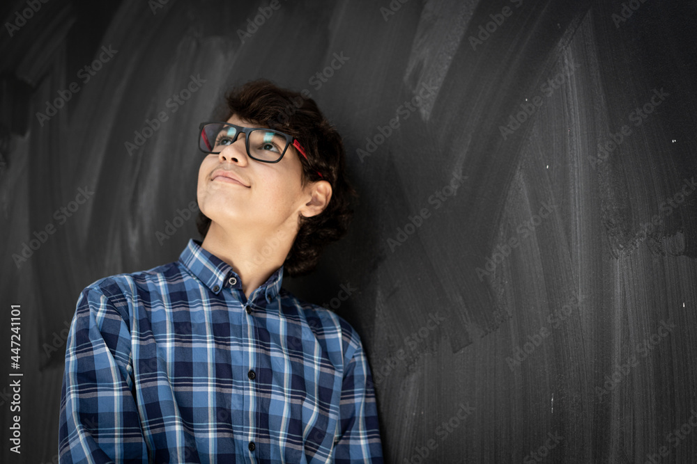 Teenage boy with glasses in front of classroom chalkboard Stock Photo ...