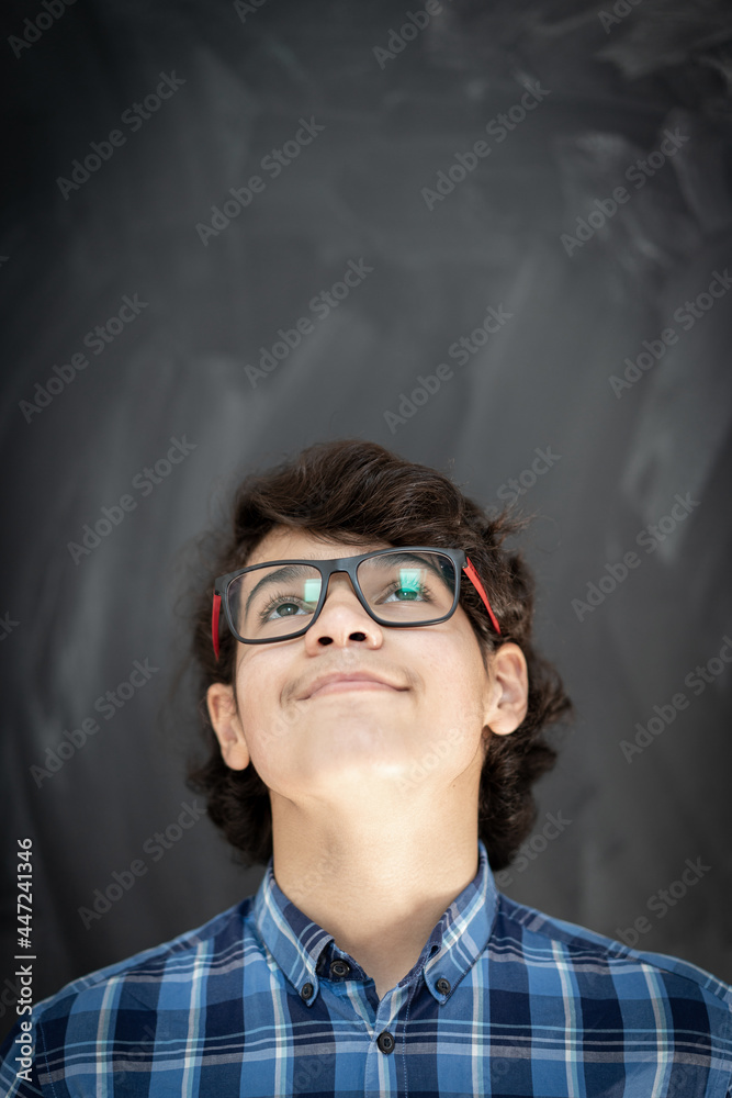 Teenage boy with glasses in front of classroom chalkboard Stock Photo ...