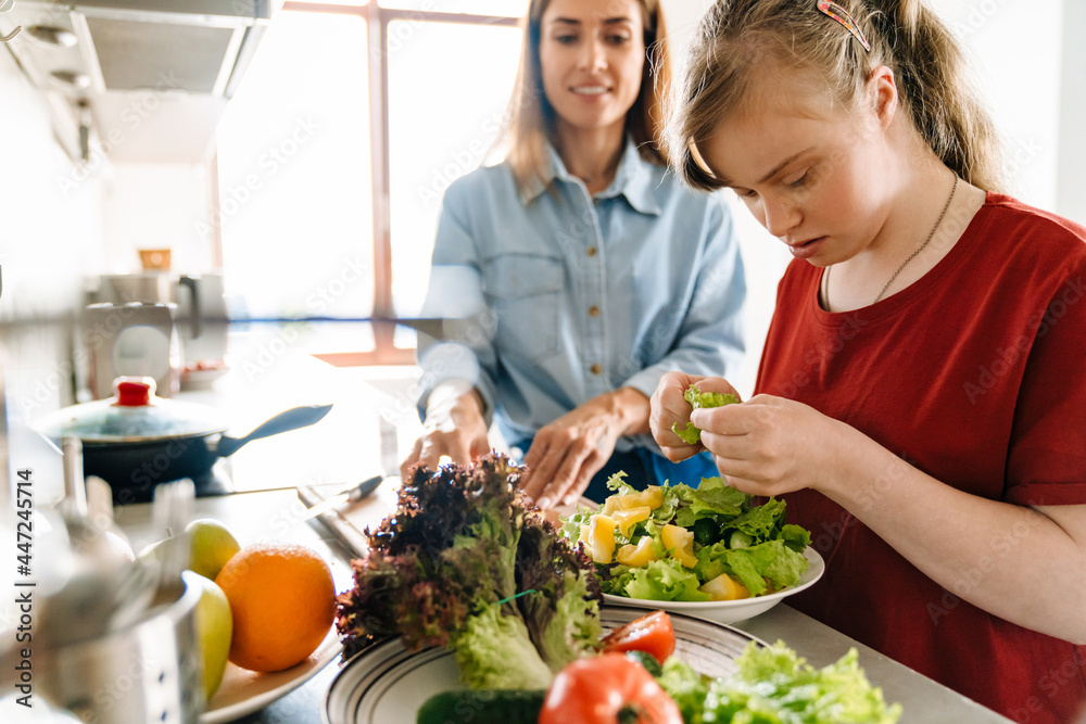 White woman and her daughter with down syndrome cooking salad Stock ...