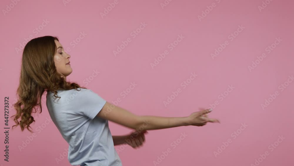 Side view of purposeful wavy haired teenager girl in casual T-shirt ...