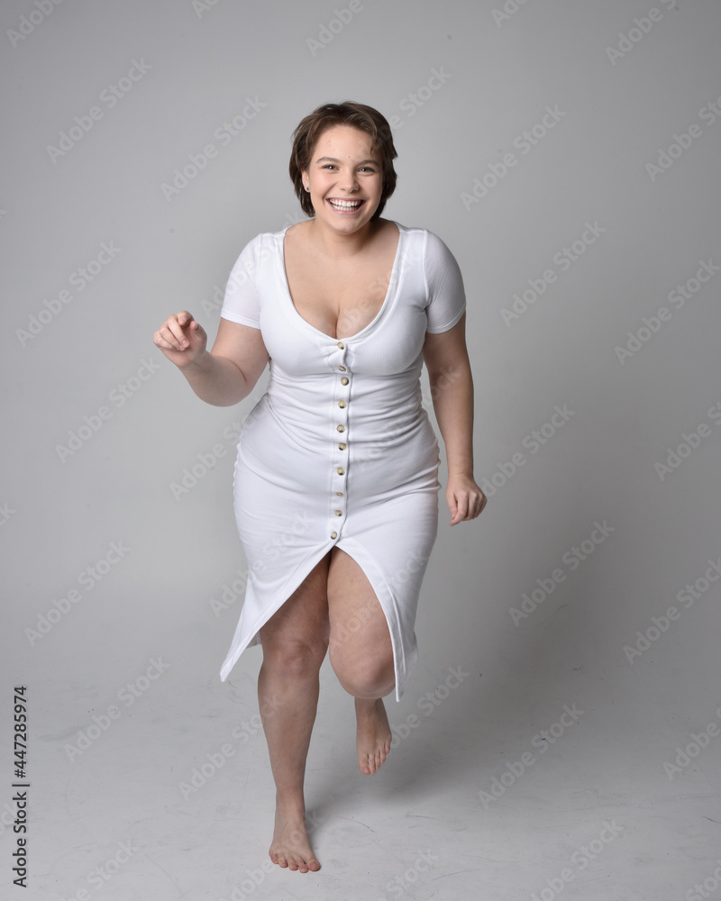 Full length portrait of young plus sized woman with short brunette hair ...