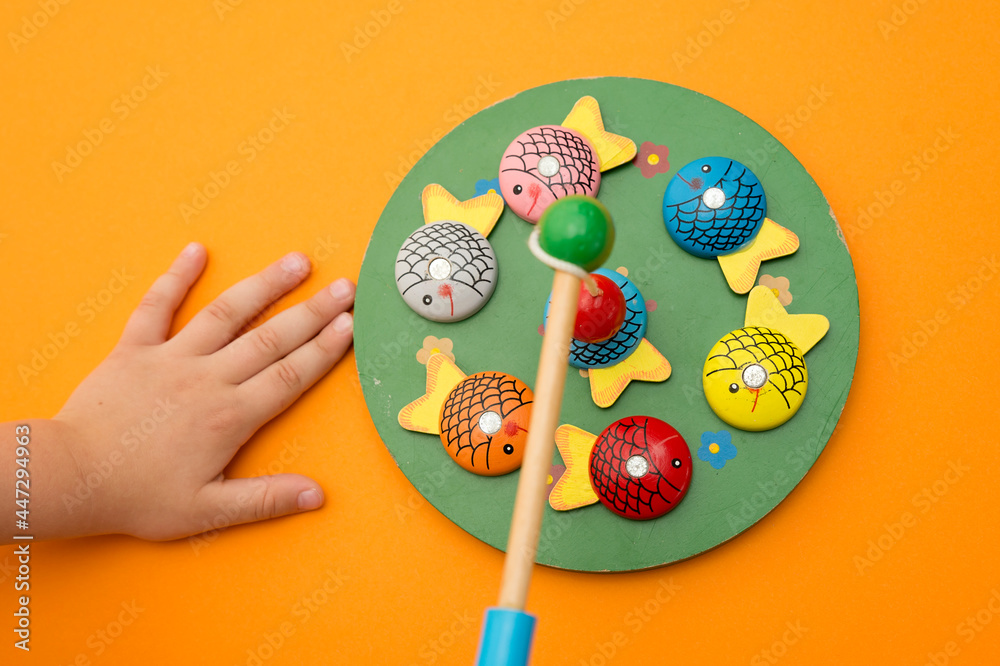 Let's go fishing. Wooden fishes and fishing rod with magnet on the tip ...