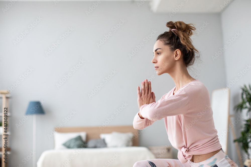 Beautiful woman in a praying pose relaxes at home. Stock Photo | Adobe ...