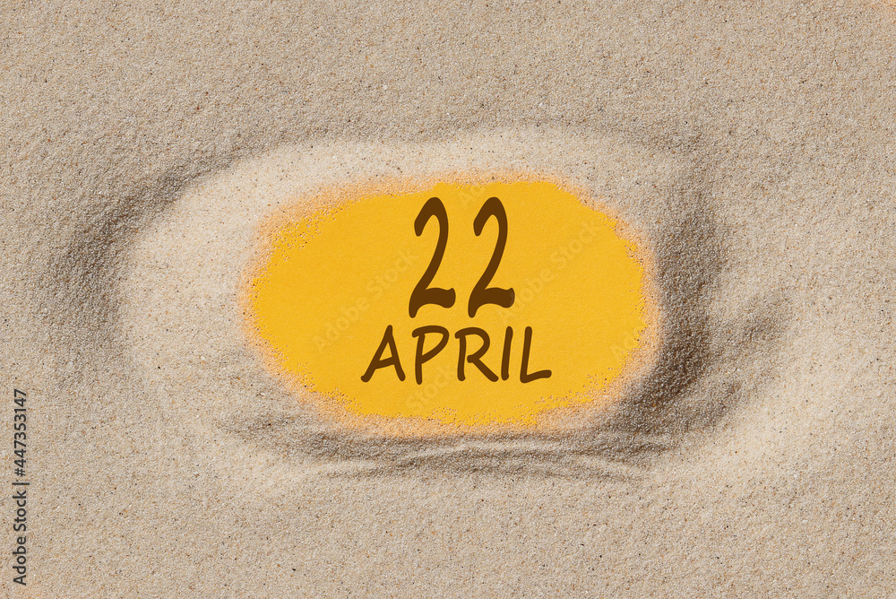April 22. 22th day of the month, calendar date. Hole in sand. Yellow ...