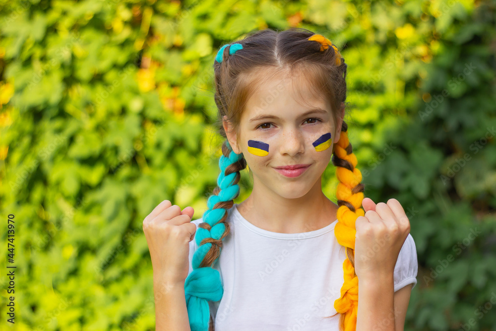 joyful Ukrainian girl with blue and yellow flags painted on her cheeks ...