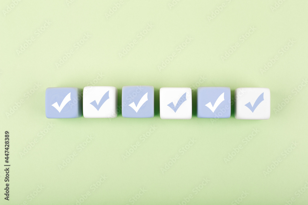 Top view of six blocks with check marks on light pastel green ...