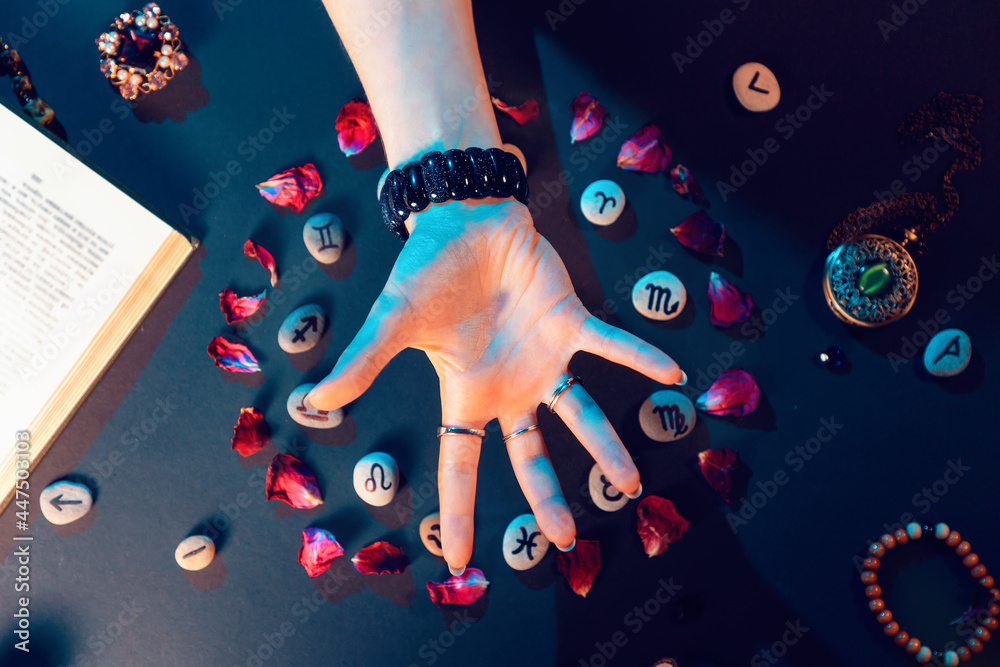 The concept of divination and magic. A female's hand conjures stones ...