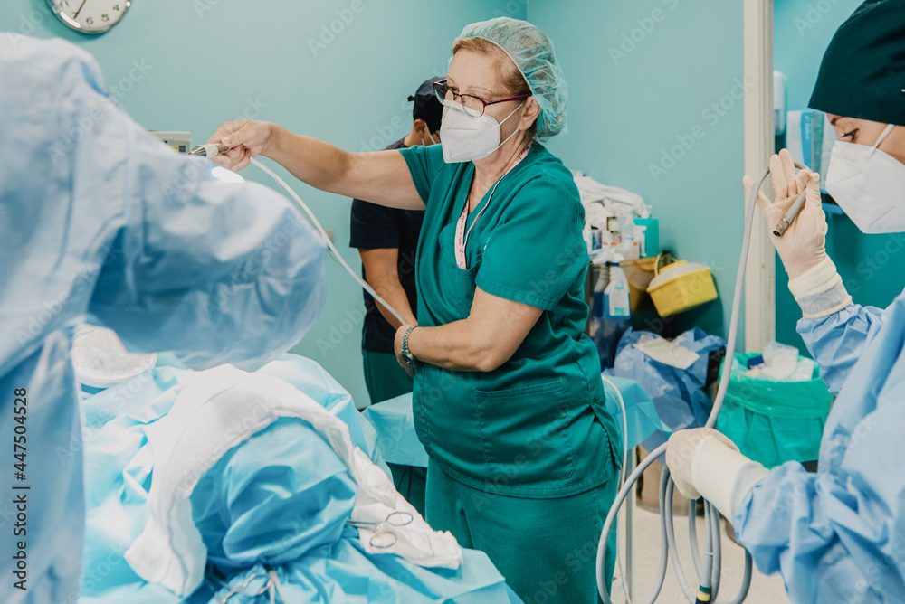 Medical doctors preparing patient in operating room at modern hospital ...