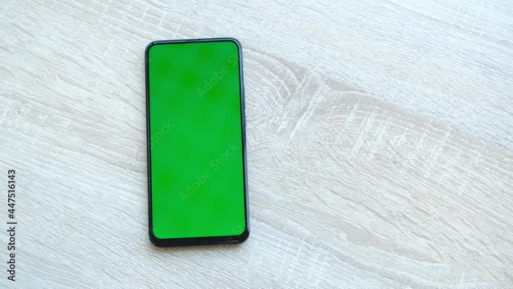 Smart phone place on table wood with green screen, Close-up the cell ...