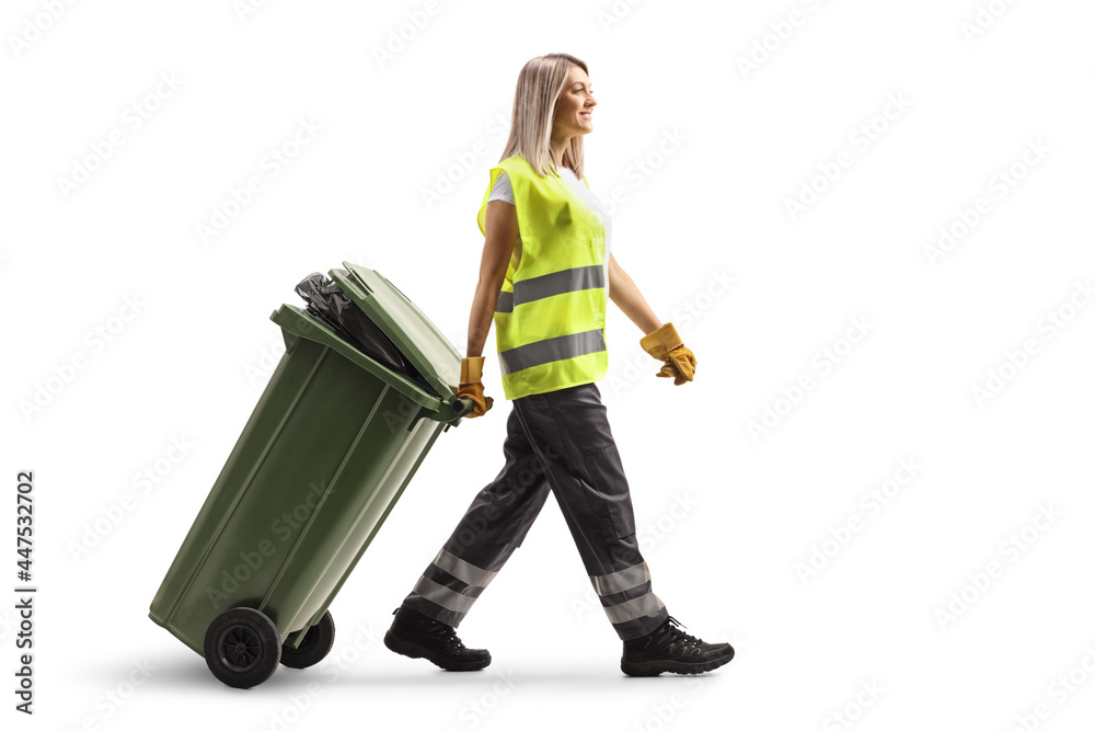 Female waste collector in a uniform and gloves walking and pulling a ...