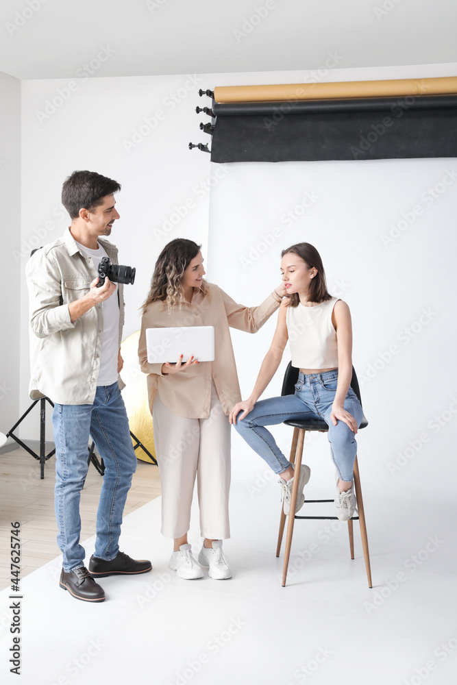 Stylist and photographer working with model in studio Stock Photo ...