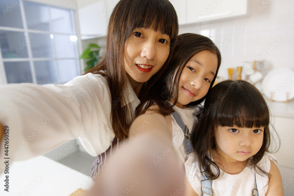 Foto de Cute and beautiful mother with two young and little daughters ...