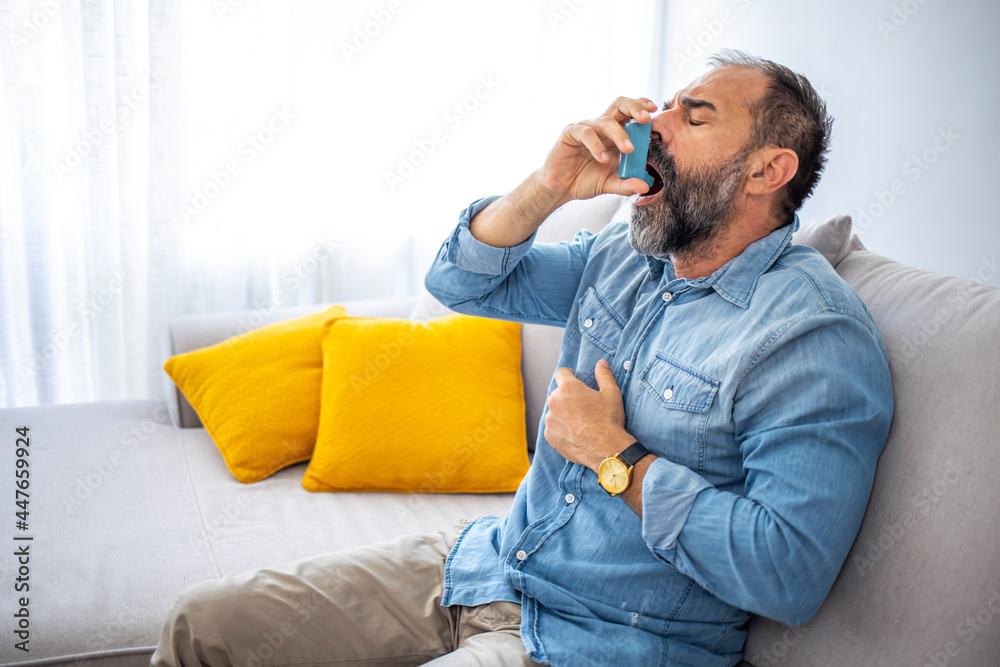 Foto de Man using asthma inhaler. Man using asthma inhaler for relief ...