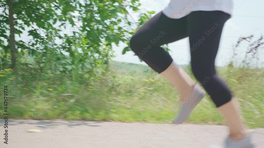 Close up video of the legs of the woman jogging early in the morning on ...