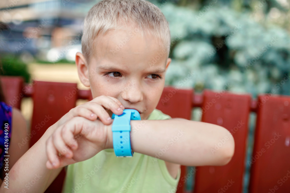 Little boy talking with his mother on smartwatch during walking, care ...