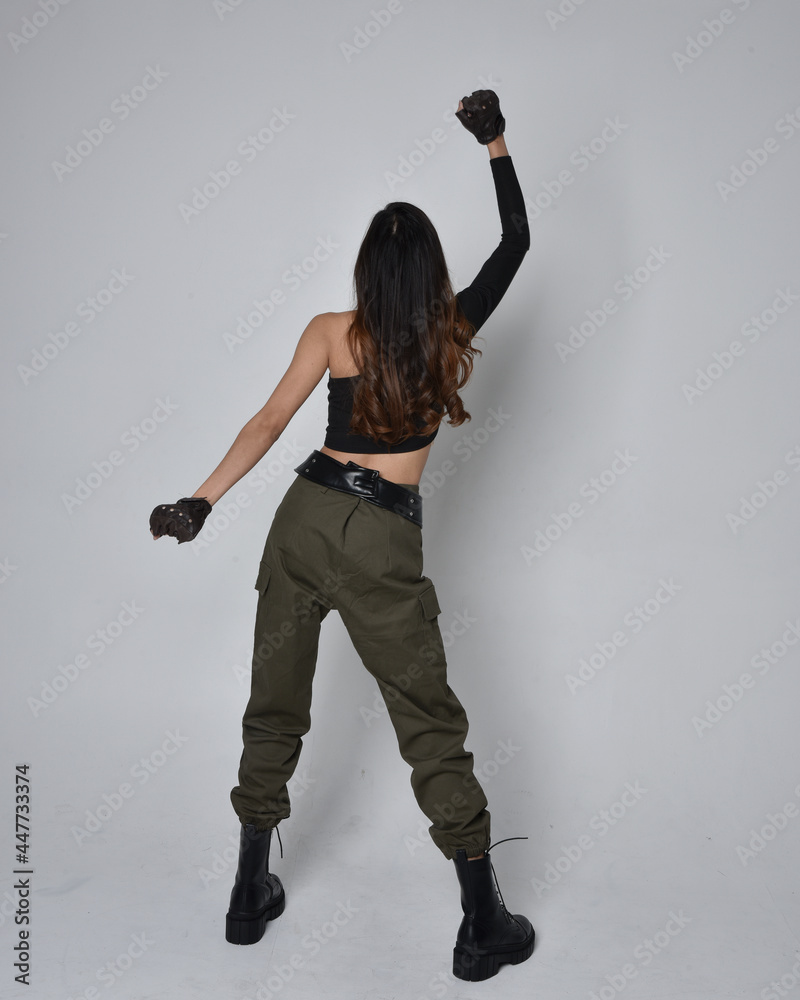 Full length portrait of pretty brunette, asian girl wearing black top ...