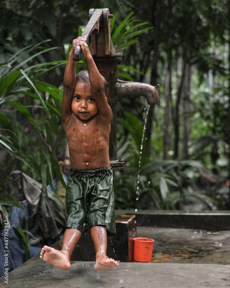 Bangladeshi village child taking bath from tube well. sweet childhood ...