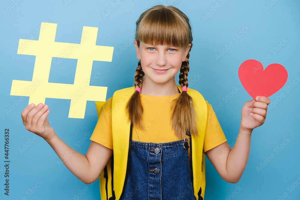 Beautiful cute schoolgirl holding big yellow hashtag and little red ...