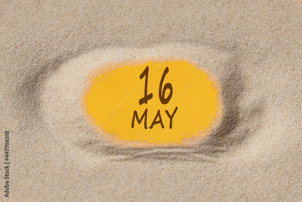 May 16. 16th day of the month, calendar date. Hole in sand. Yellow ...