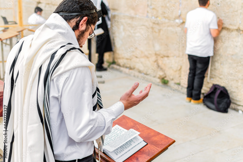 Young Orthodox Jewish man praying with phylacteries (tefilin), at the ...