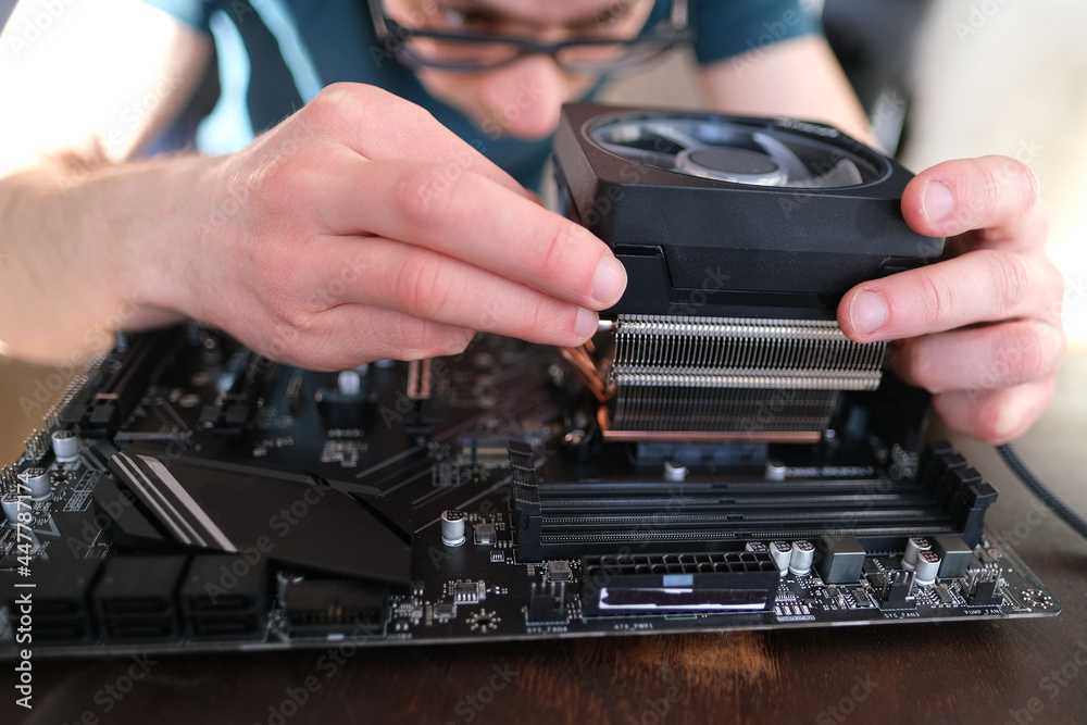 hands of young male master install cooler with copper heat pipes for ...
