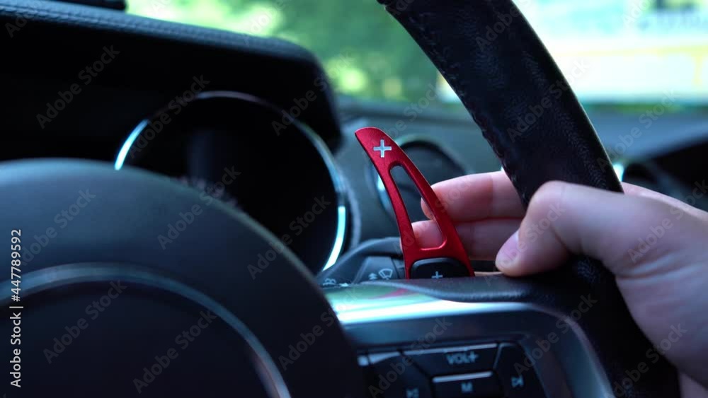 Driver behind the wheel of the car, hands wrap around the steering ...