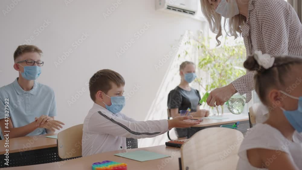 Teacher, children with face mask at school after lockdown, disinfecting ...