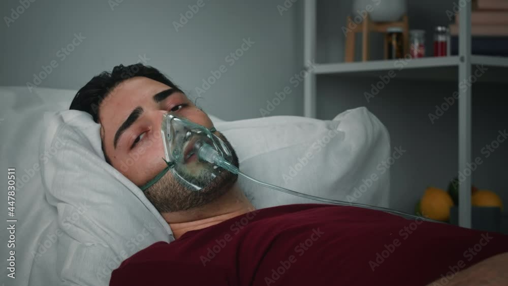 Sick patient lying with oxygen mask in hospital ward, serious bad human ...
