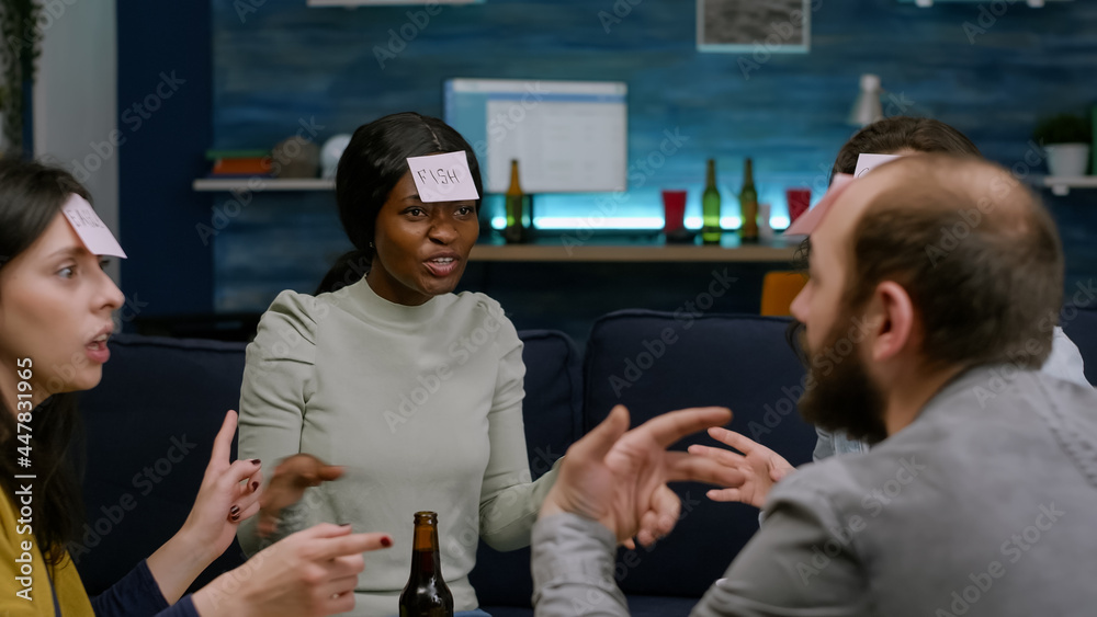 Group of multi-ethnic people laughing while playing guess who game ...
