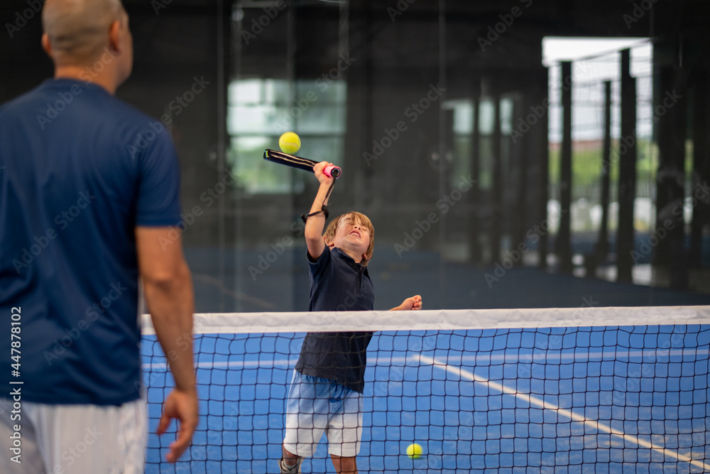 Monitor teaching padel class to child, his student - Trainer teaches ...