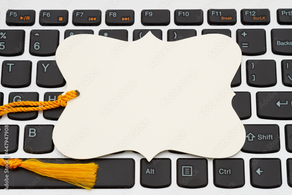 Blank gift tag with gold ribbon on keyboard Stock Photo | Adobe Stock