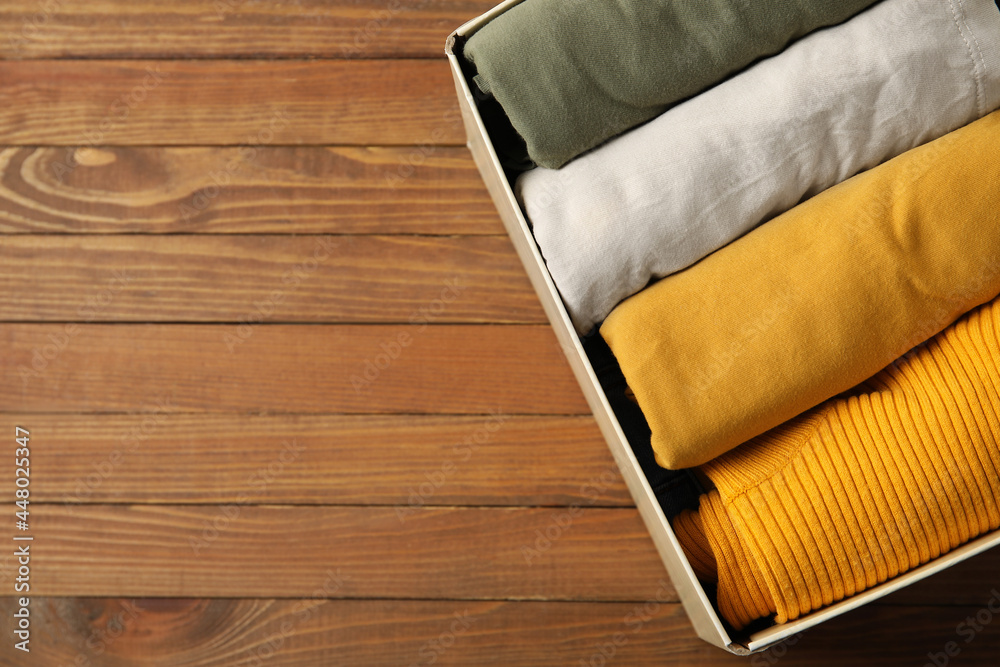 Wardrobe box with clothes on wooden background Stock Photo | Adobe Stock