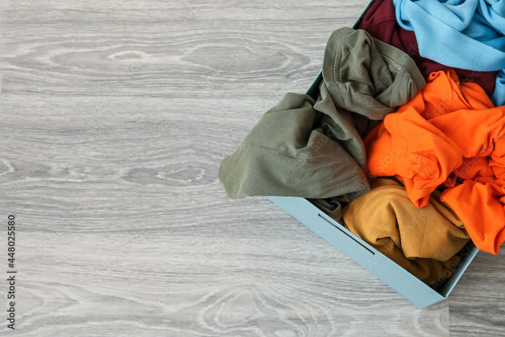 Wardrobe box with clothes on wooden background Stock Photo | Adobe Stock