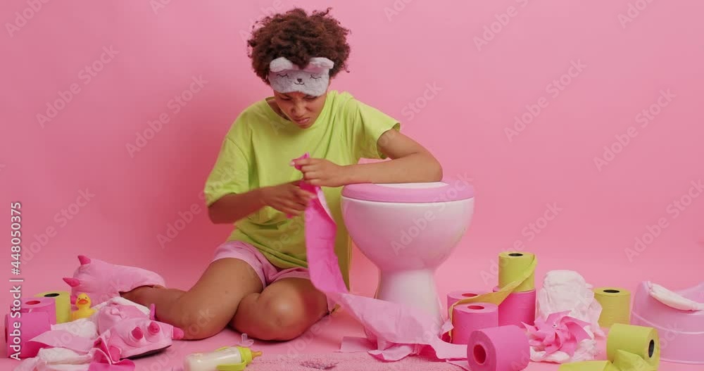 Angry irritated curly woman poses in restroom wears casual clothes ...