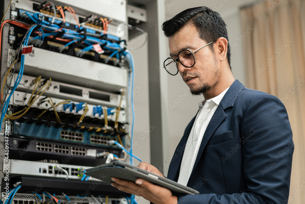 Stock photo of a young network technician holding tablet working to ...